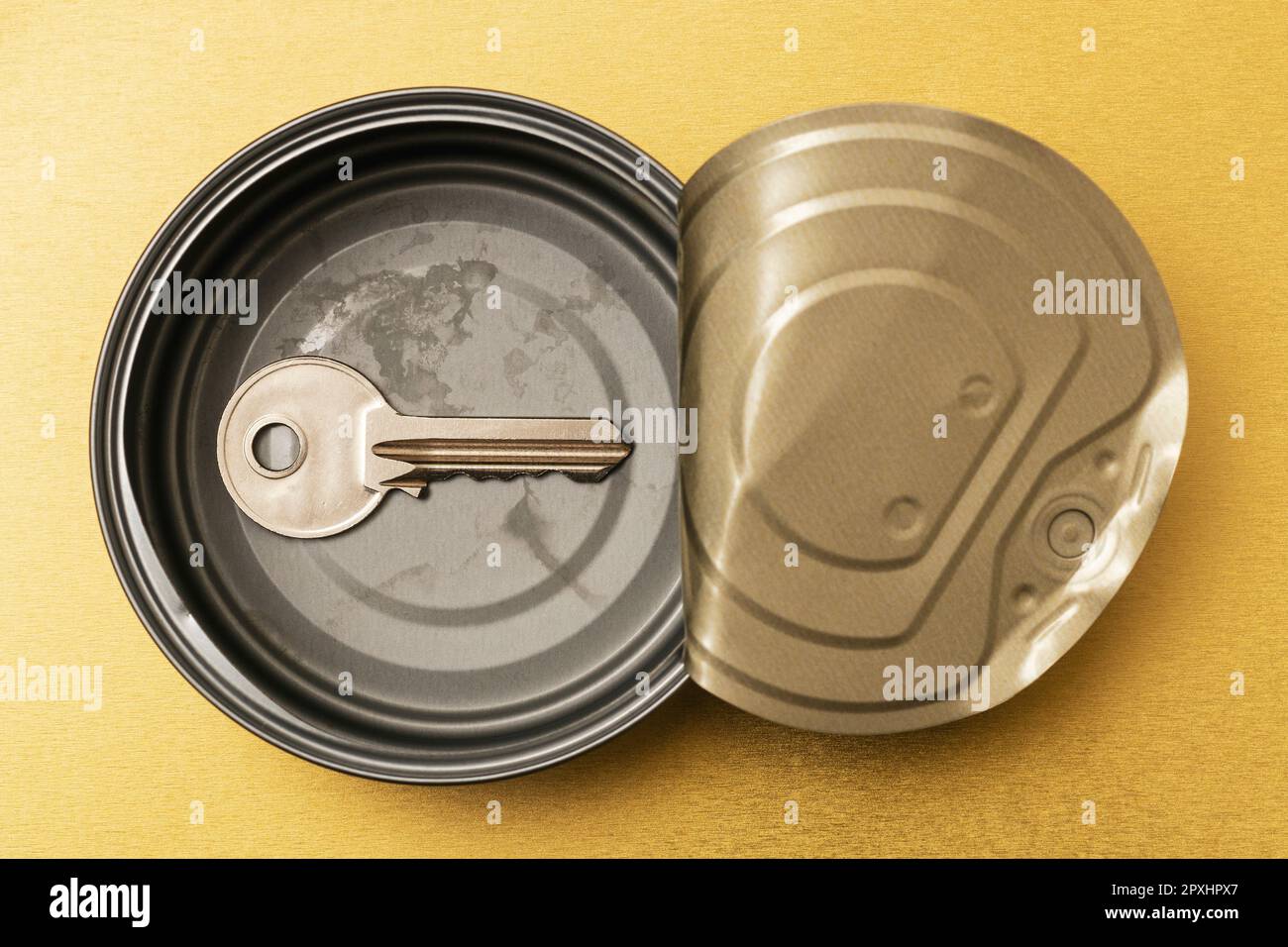 Opened tin can with a door key inside. Conceptual image Stock Photo - Alamy