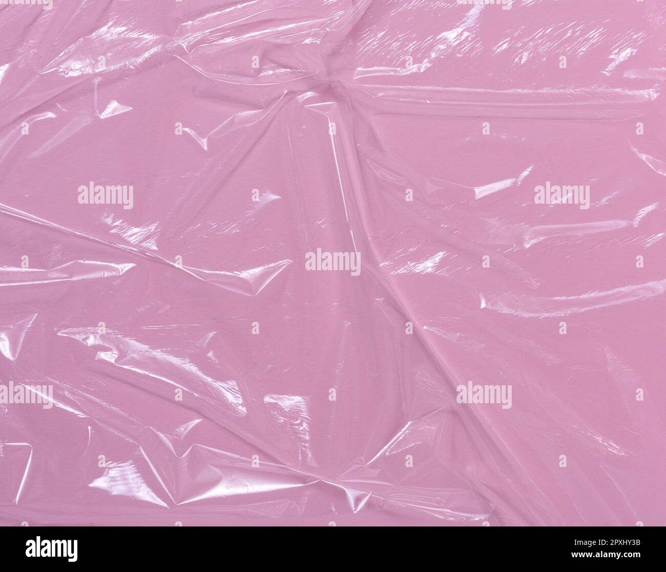 Texture of crumpled transparent polyethylene on a pink background, full ...