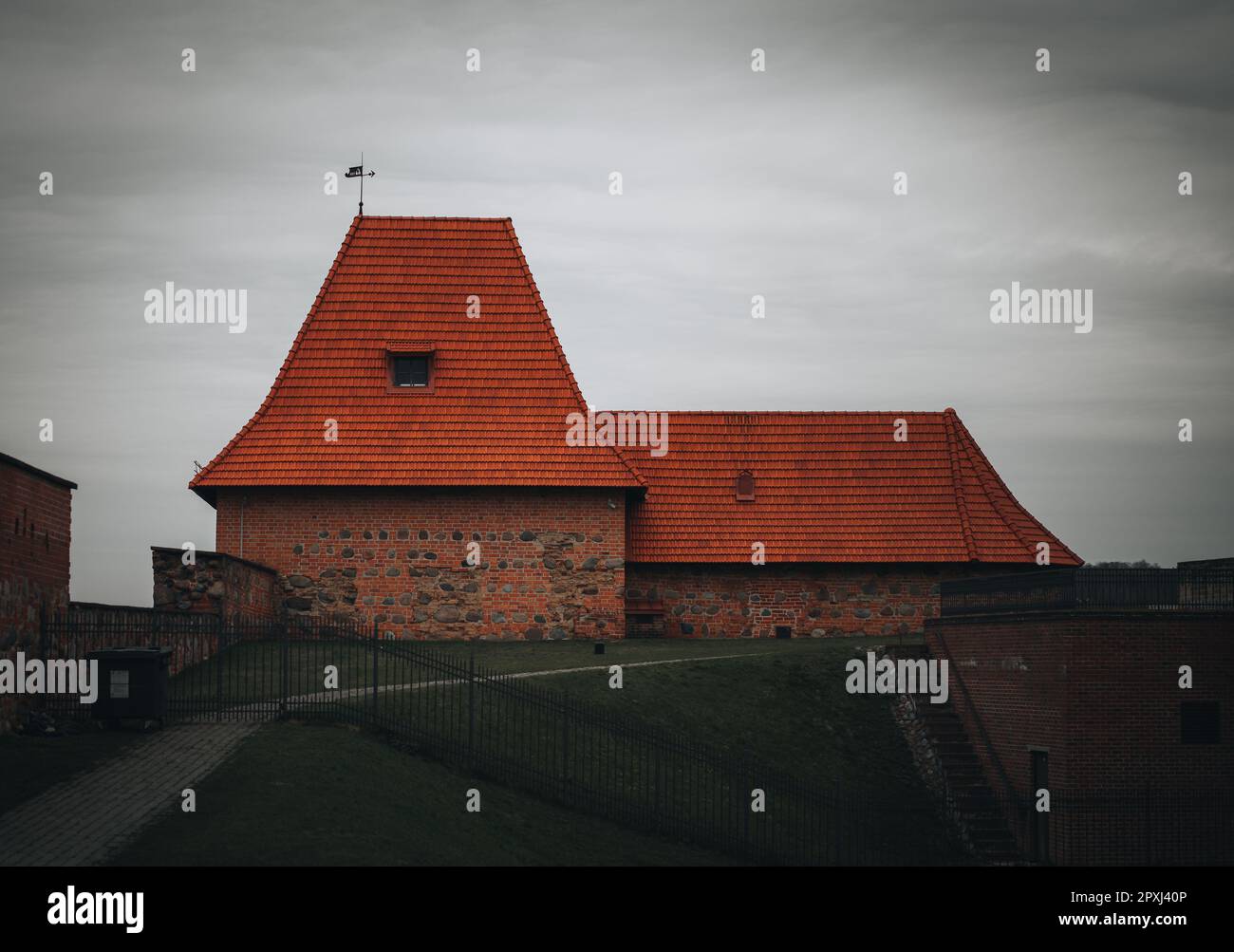 A vibrant red-tiled building stands prominently against the skyline ...