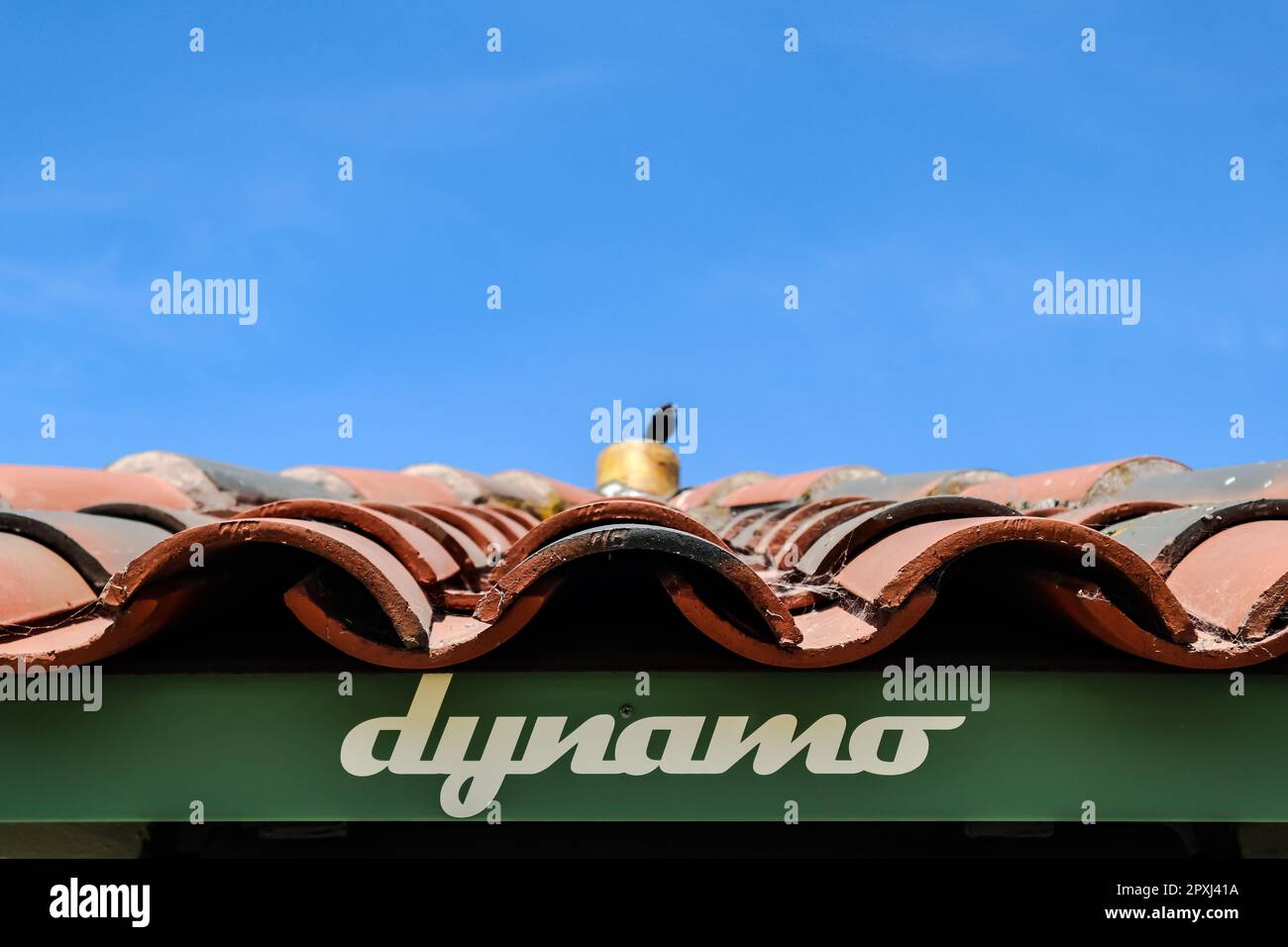 A green sign displaying the word 'Dynamo' under the terracotta roof ...