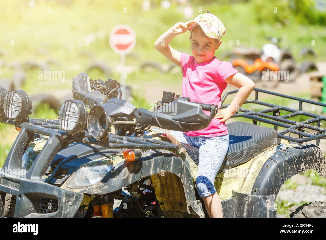 Little girl riding ATV quad bike in race track Stock Photo - Alamy