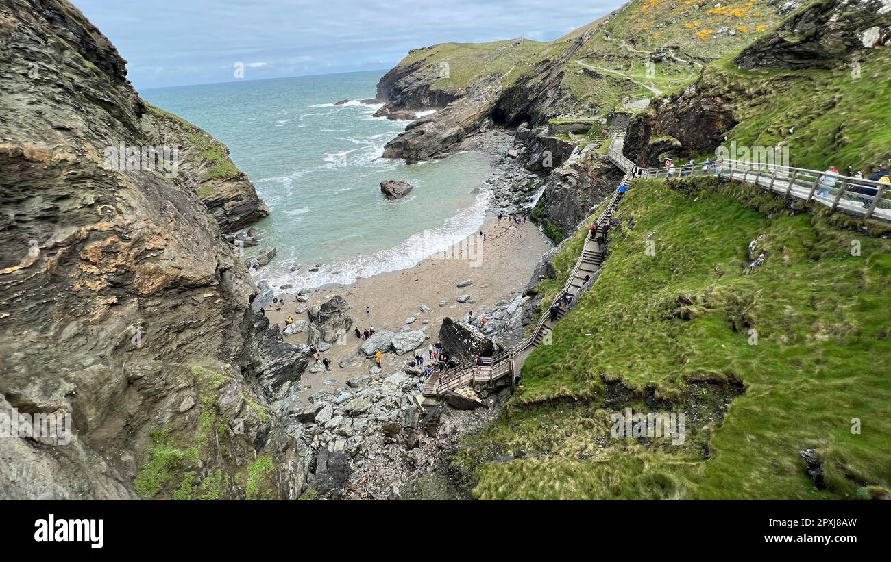 A serene view of a beach with clear blue ocean water and rocky ...