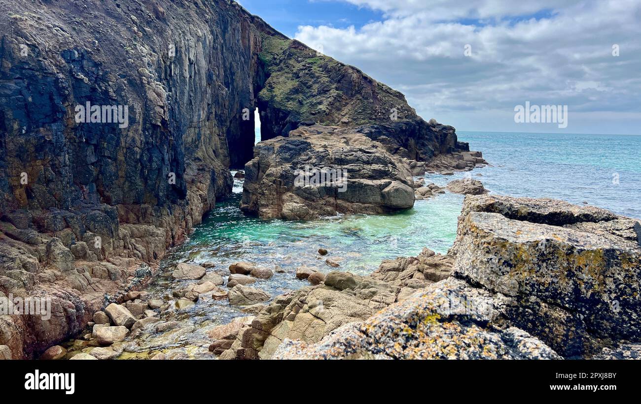 A serene view of a beach with clear blue ocean water and rocky ...
