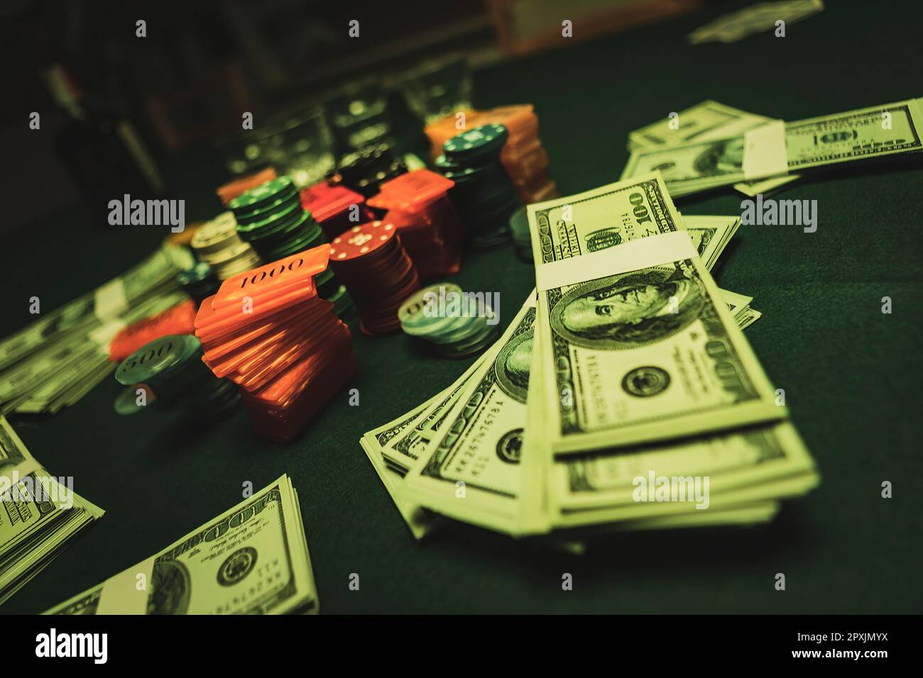 Poker chips are stacked neatly on a green textured table, the focus is ...