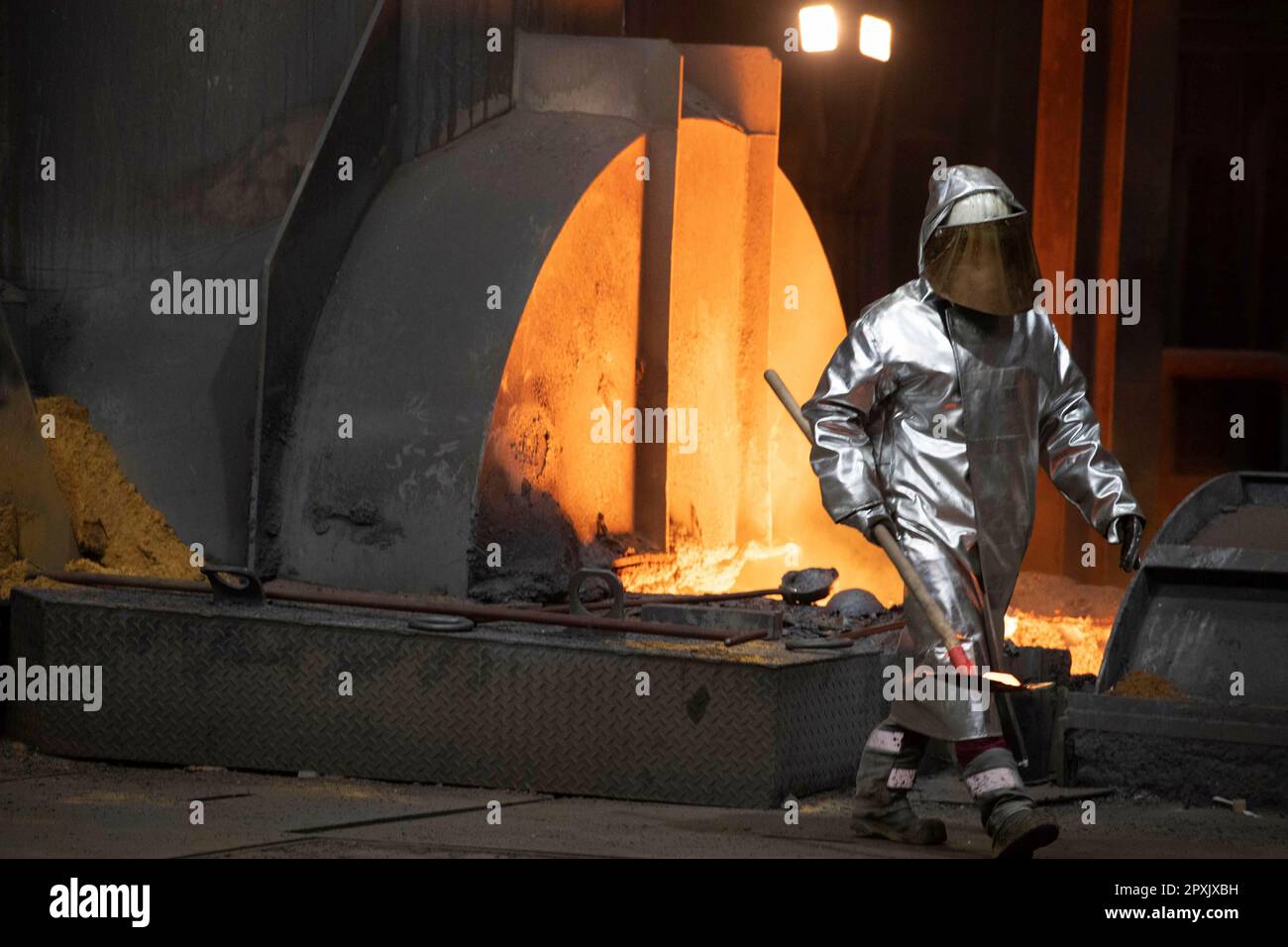 A steelworker takes a sample from the tapping of the blast furnace ...
