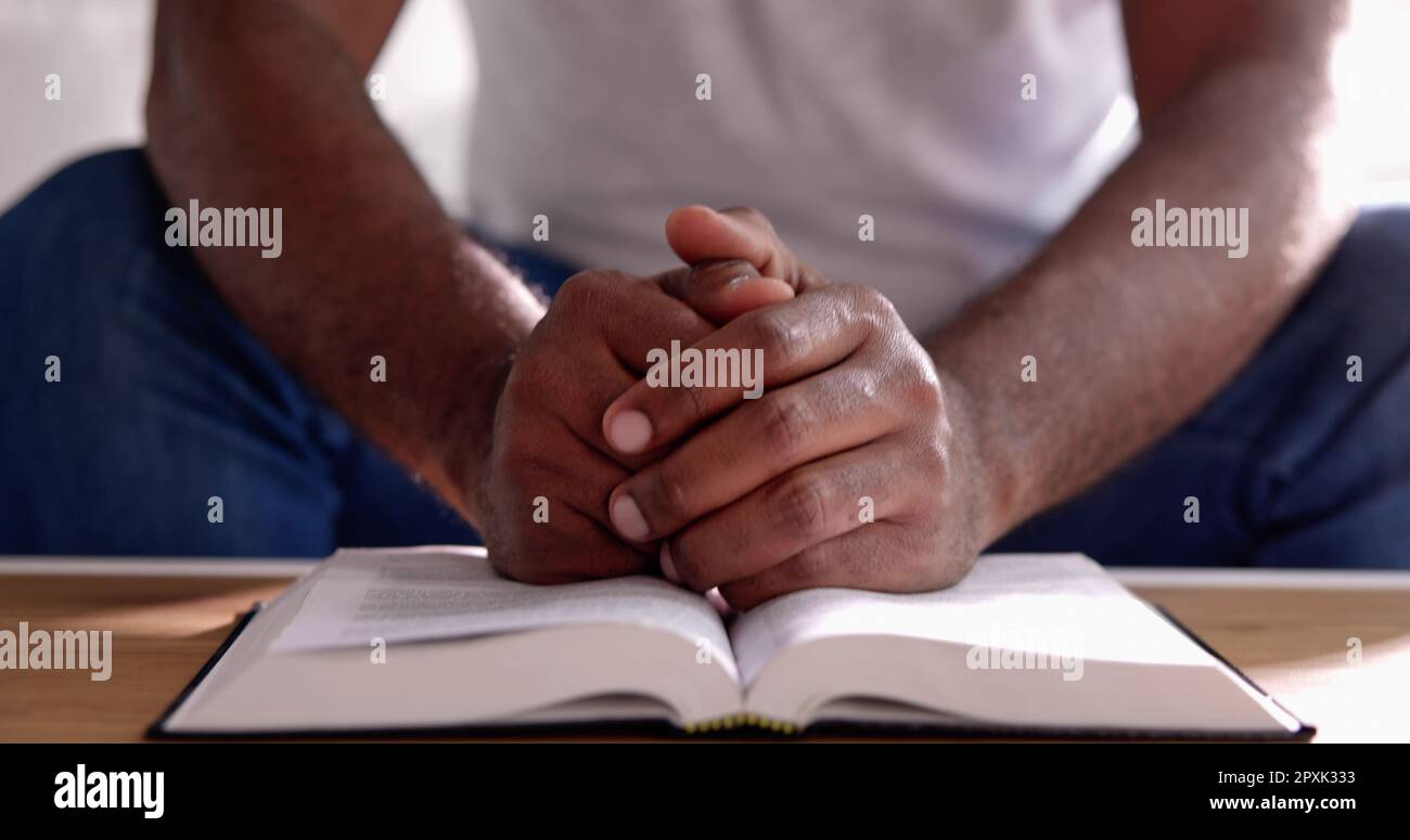 African American Black Christian. Bible In Prayer Hands Stock Photo - Alamy