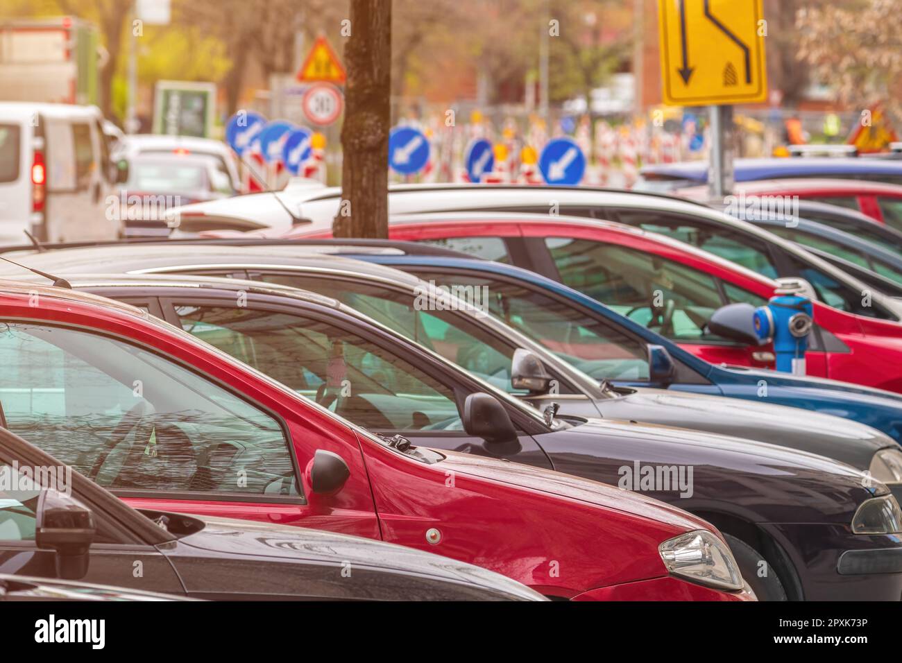 Traffic chaos at urban street, many parked cars and traffic signs ...