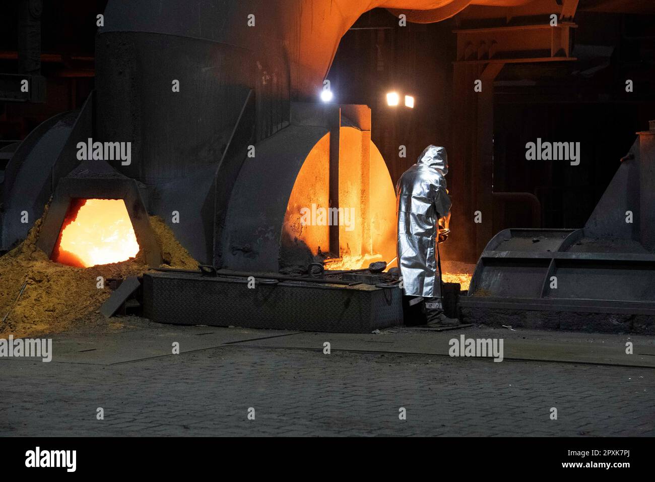 A steelworker takes a sample from the tapping of the blast furnace ...