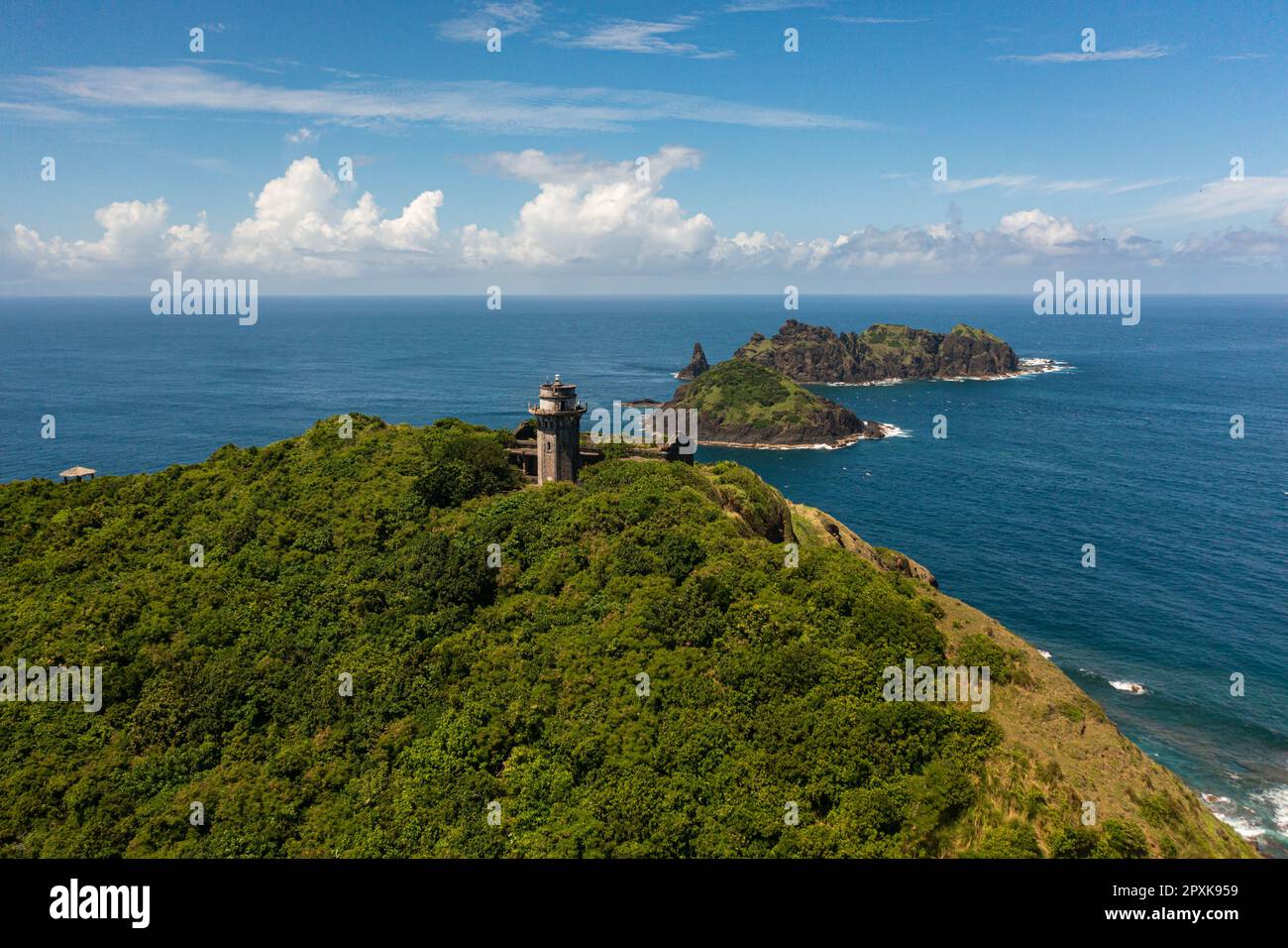 An old lighthouse on a cape against the backdrop of the ocean and blue ...