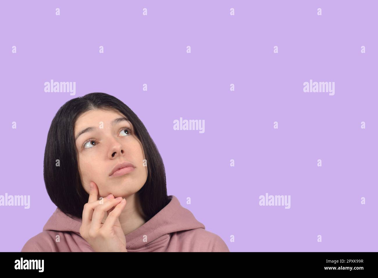 young woman looks up thoughtfully Stock Photo - Alamy