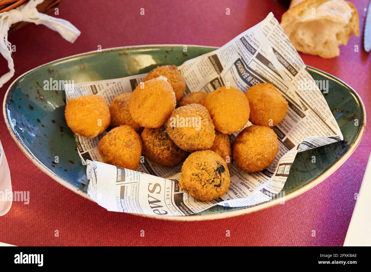 A plate of crispy, golden croquettes of different flavors with a soft ...