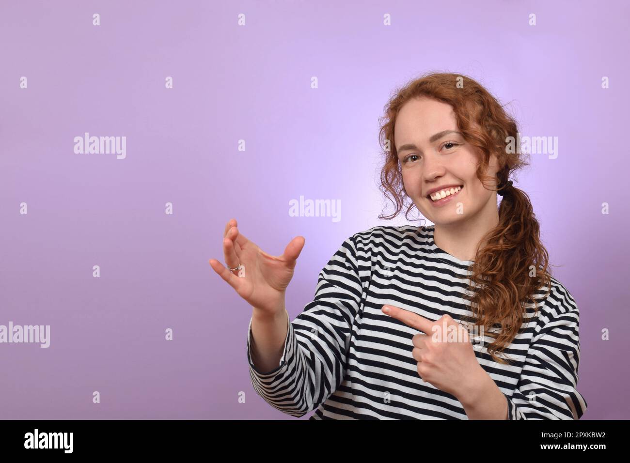 young pretty woman pointing direction with finger Stock Photo - Alamy