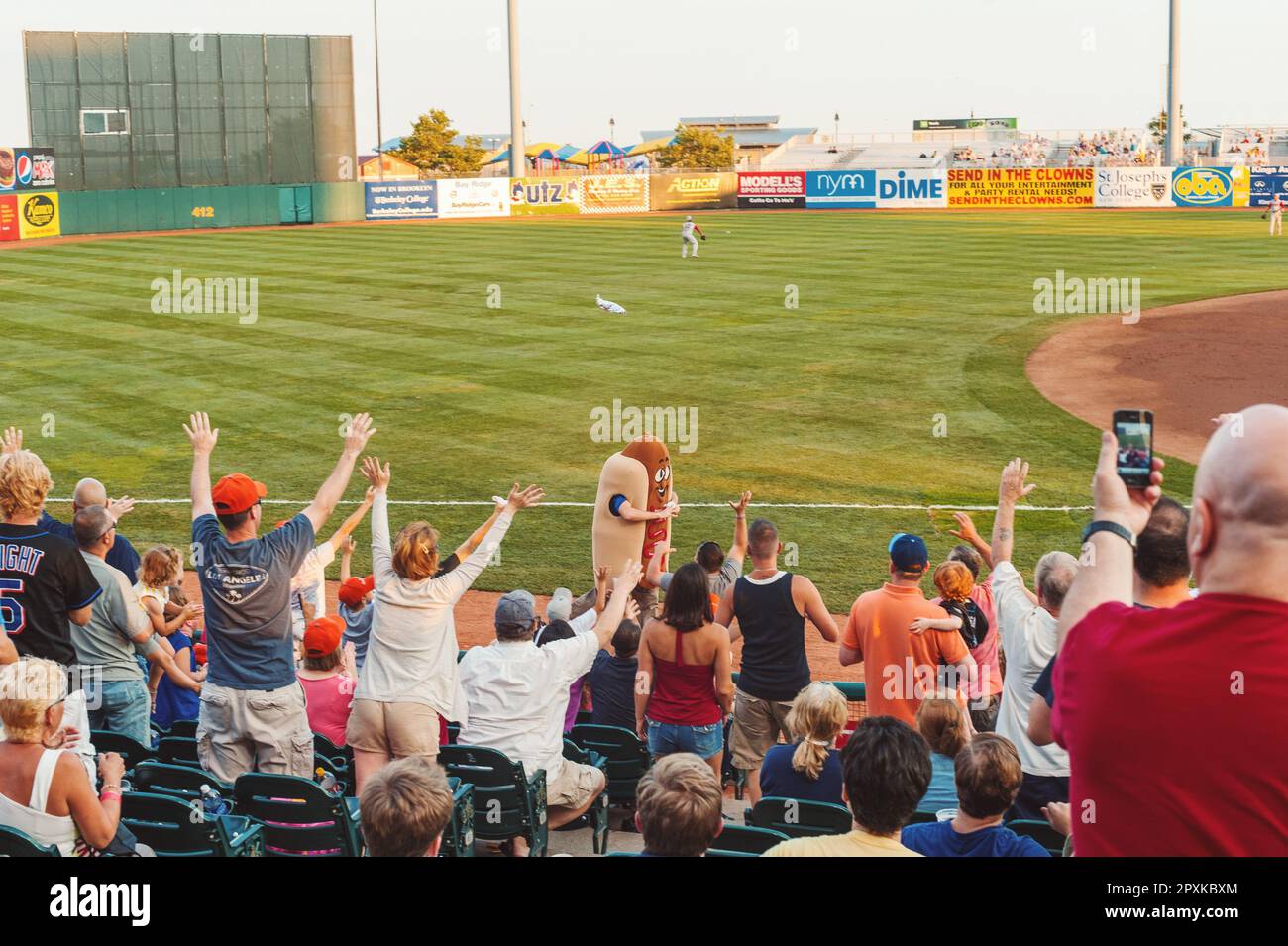 A large group of people are gathered in an arena, cheering and raising ...
