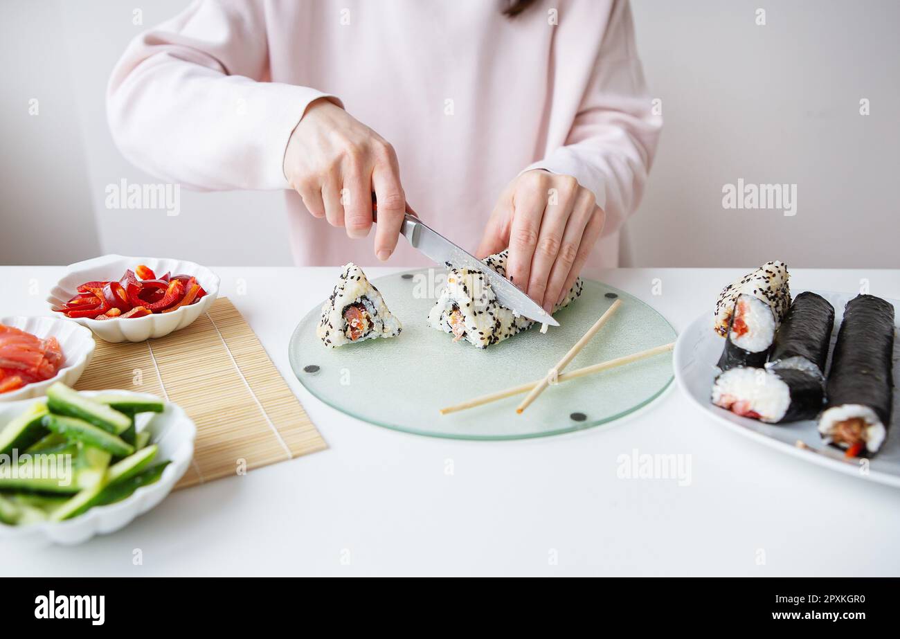 The process of making sushi, the girl makes sushi with different ...
