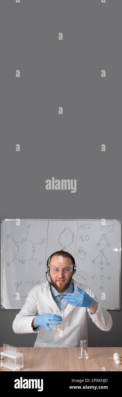 a chemistry teacher in white sits on a chair against the background of ...