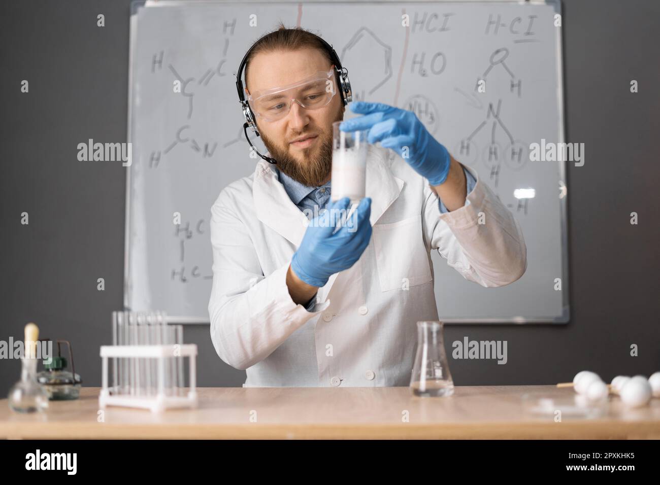 Online remote learning. Teacher with chemical flask showing experiments ...