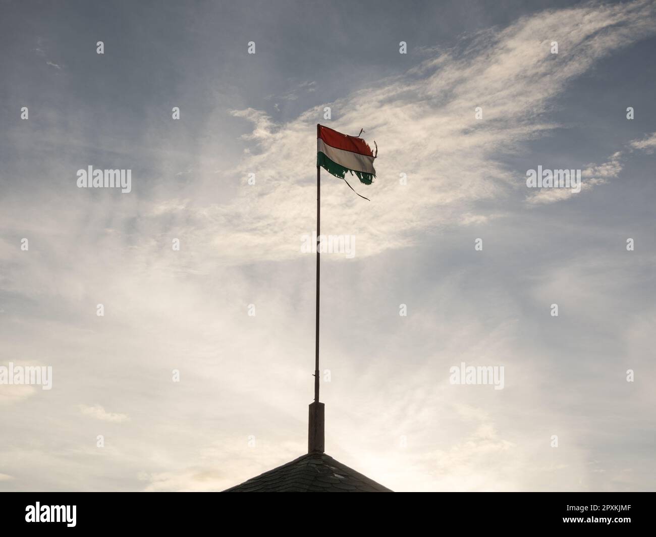 waving torn Hungarian flag in the sky Stock Photo - Alamy