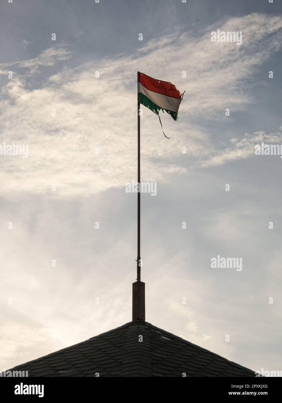 waving torn Hungarian flag in the sky Stock Photo - Alamy