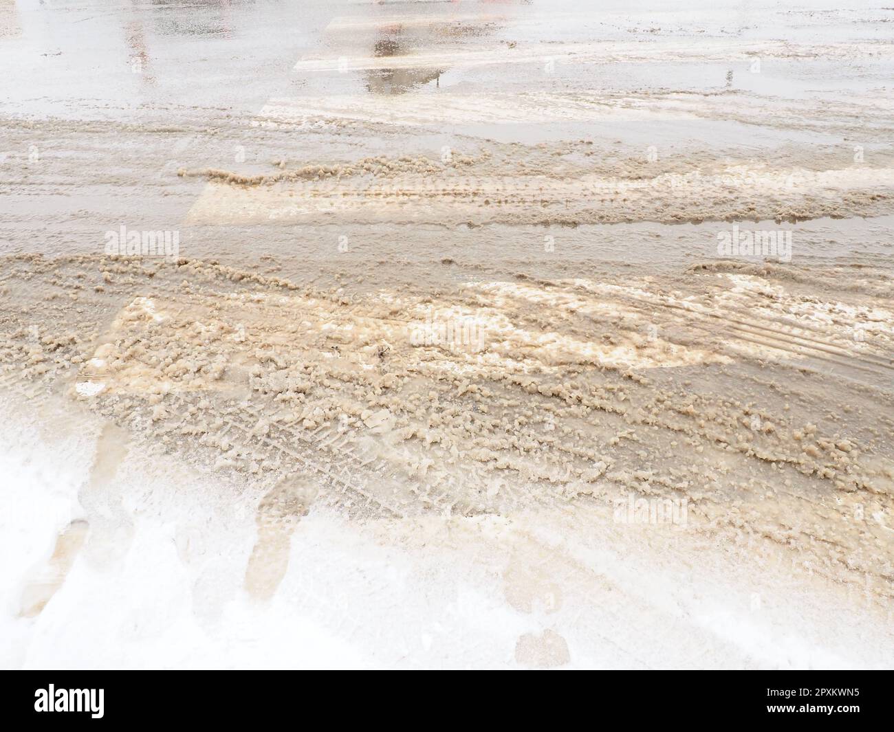 Snow, ice, slush and winter mud at a pedestrian crossing. The air ...