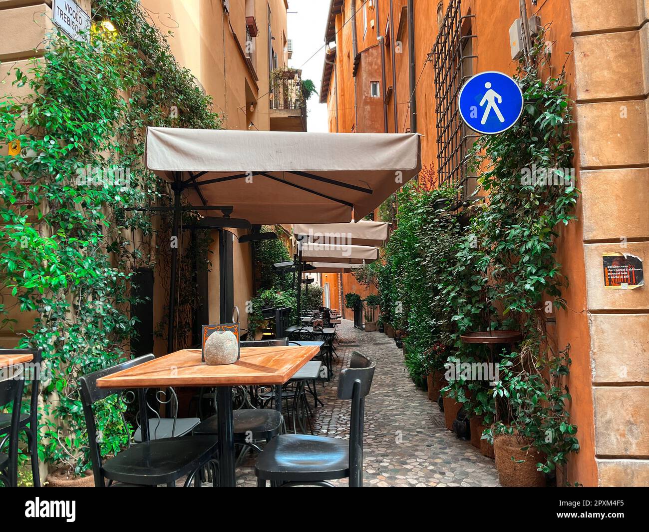 A picturesque outdoor cafe in a cobbled alley in Bologna, Italy Stock ...