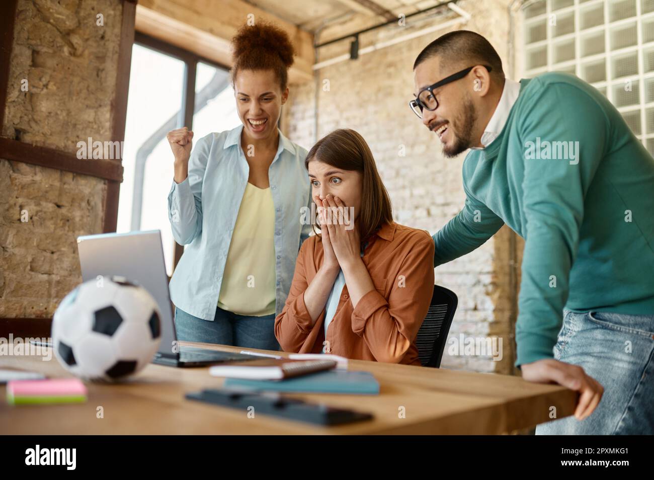 Excited young coworkers rejoicing looking at laptop screen. Cheering ...