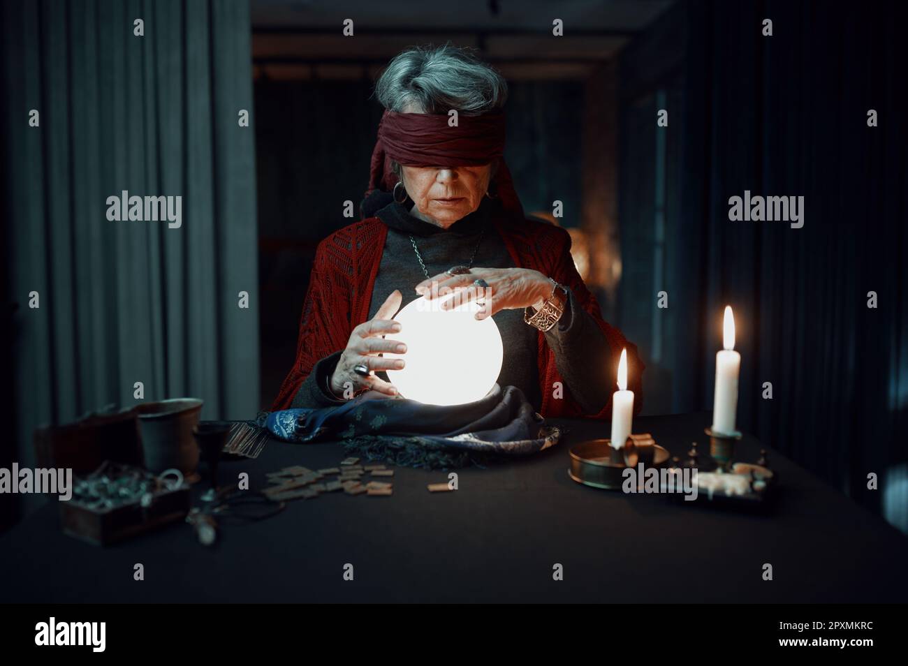 Blindfolded fortune teller medium using glowing crystal ball for future ...