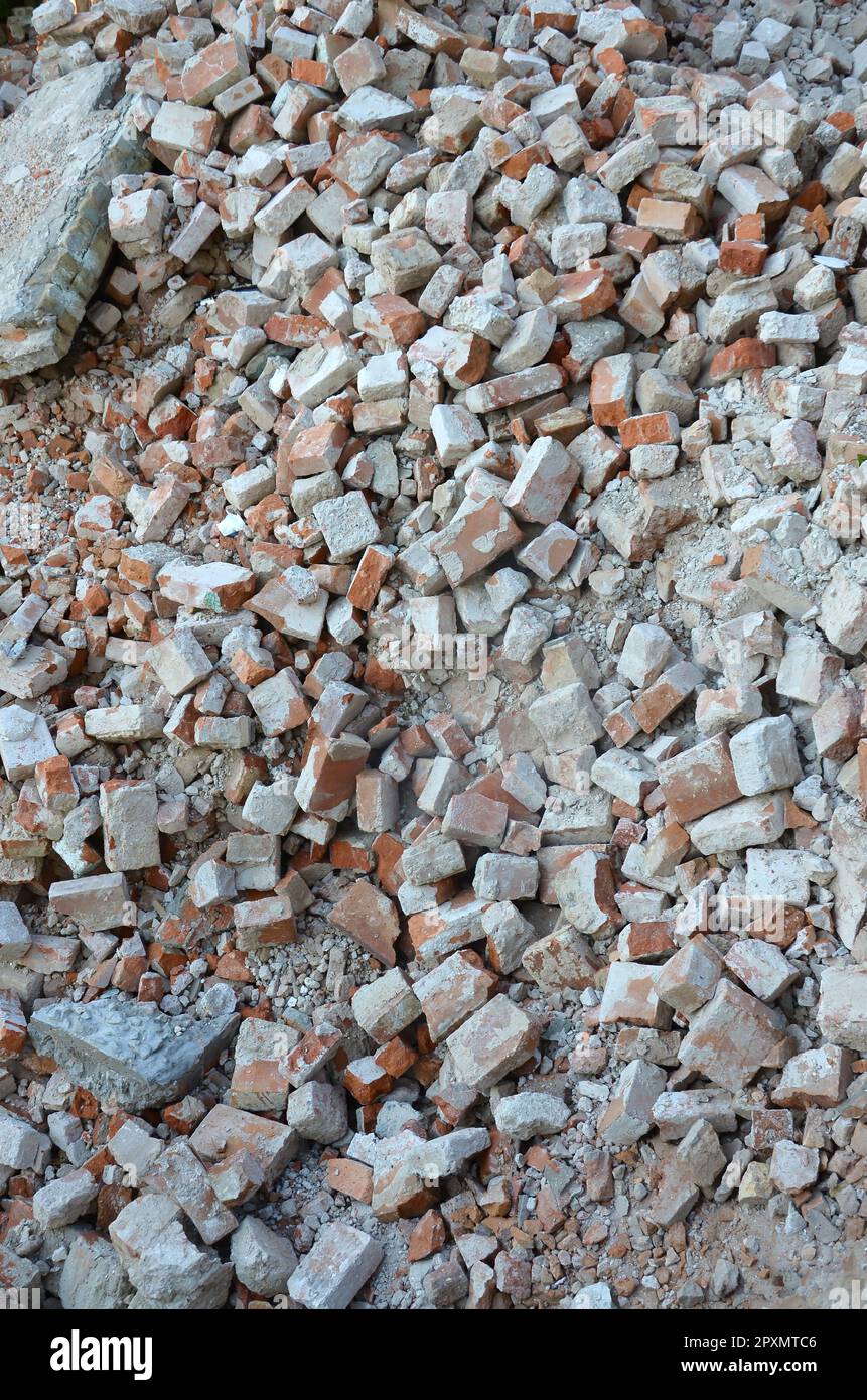 Pile of broken red bricks and fragments of concrete from destroyed building. Broken bricks close ...
