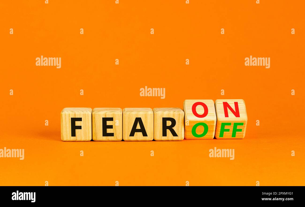 Fear on or off symbol. Businessman turns wooden cubes and changes word Fear off to Fear on ...