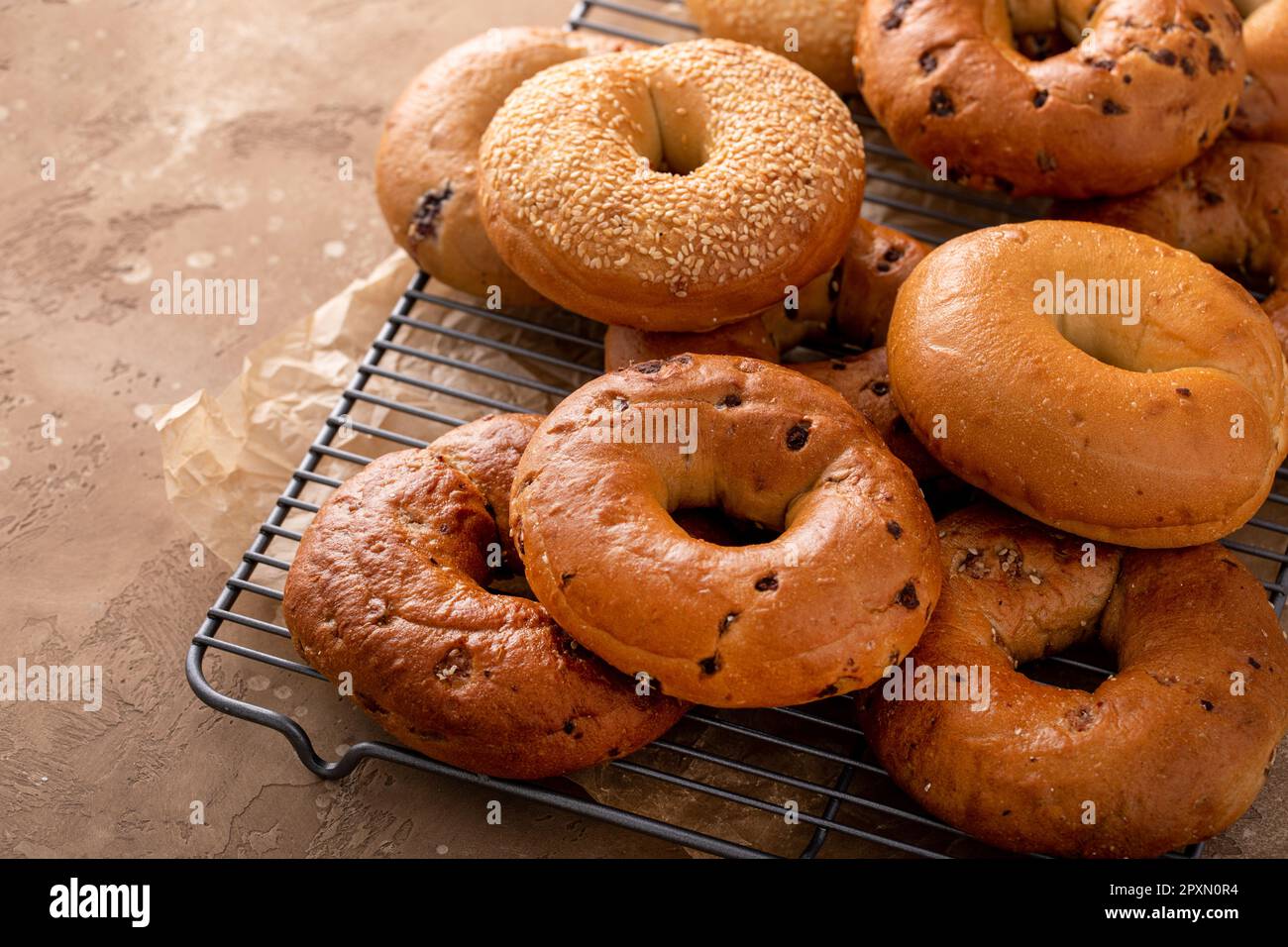 Variety of freshly baked bagels on a cooling rack ready for breakfast ...