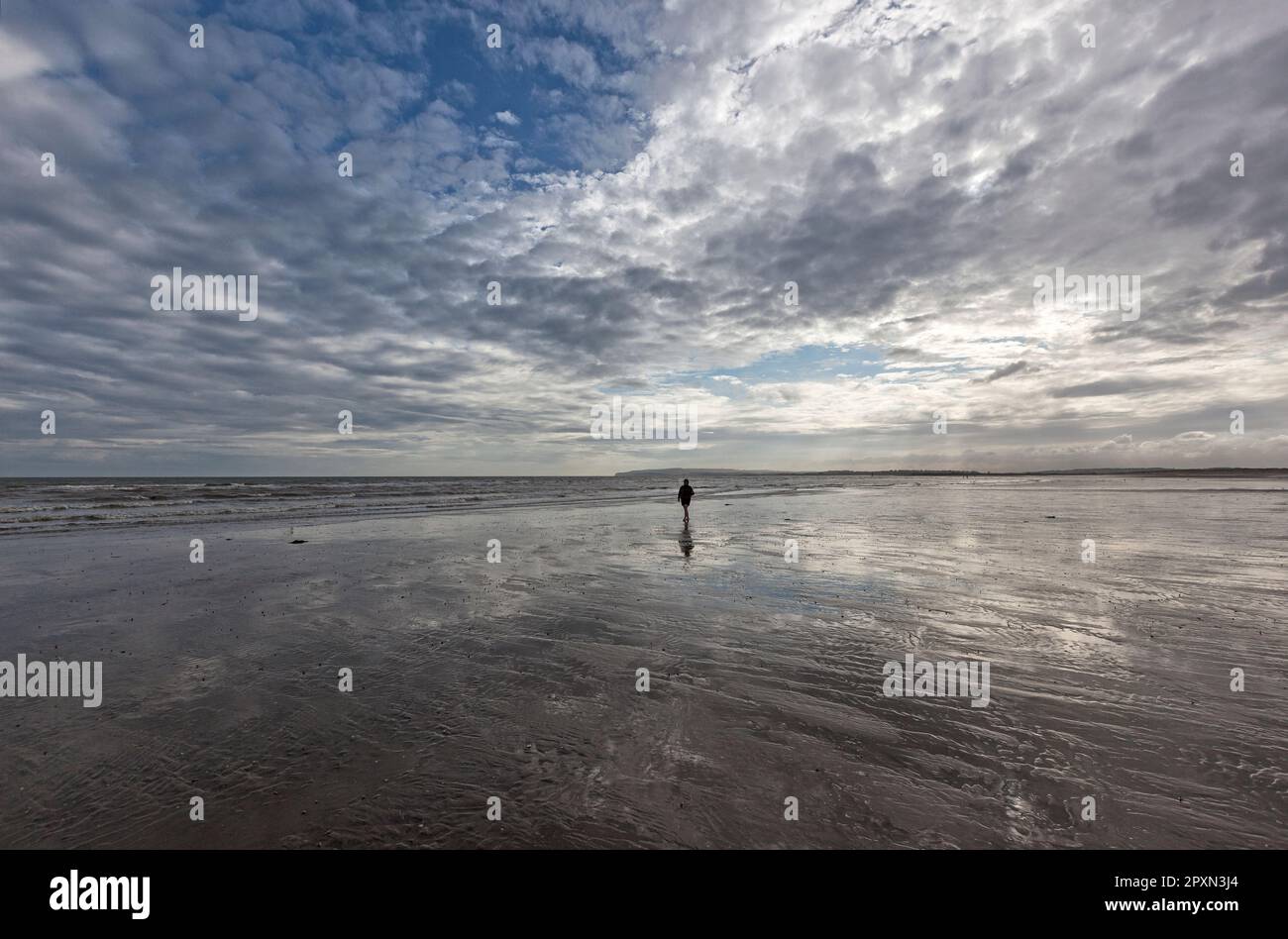 Lone person on peaceful sunny windy Camber Sands at Rye Bay by English ...