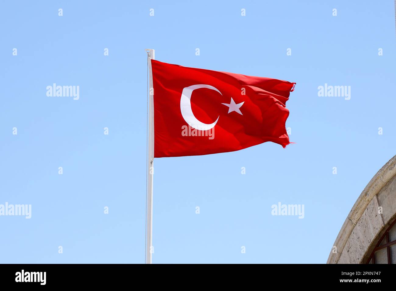 Turkish flag on flagpole waving in clean blue sky background. White ...