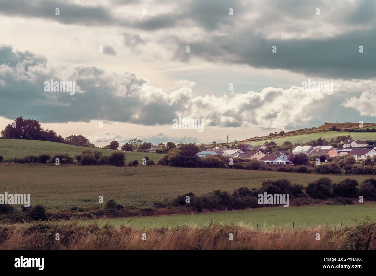 Sky with cumulus clouds over a small Irish village on a summer evening ...
