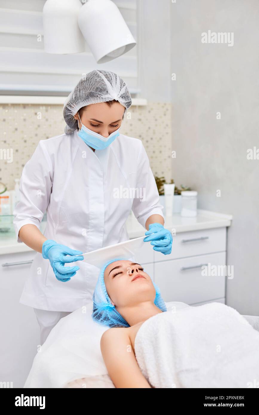 beautician cleanses skin of face of beautiful woman . Perfect cleaning, spa treatment skincare ...