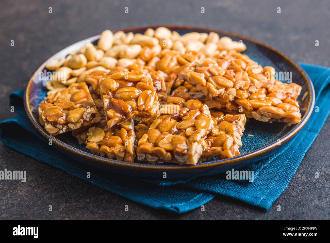 Sweet peanut brittle. Tasty peanuts in caramel on the plate Stock Photo ...