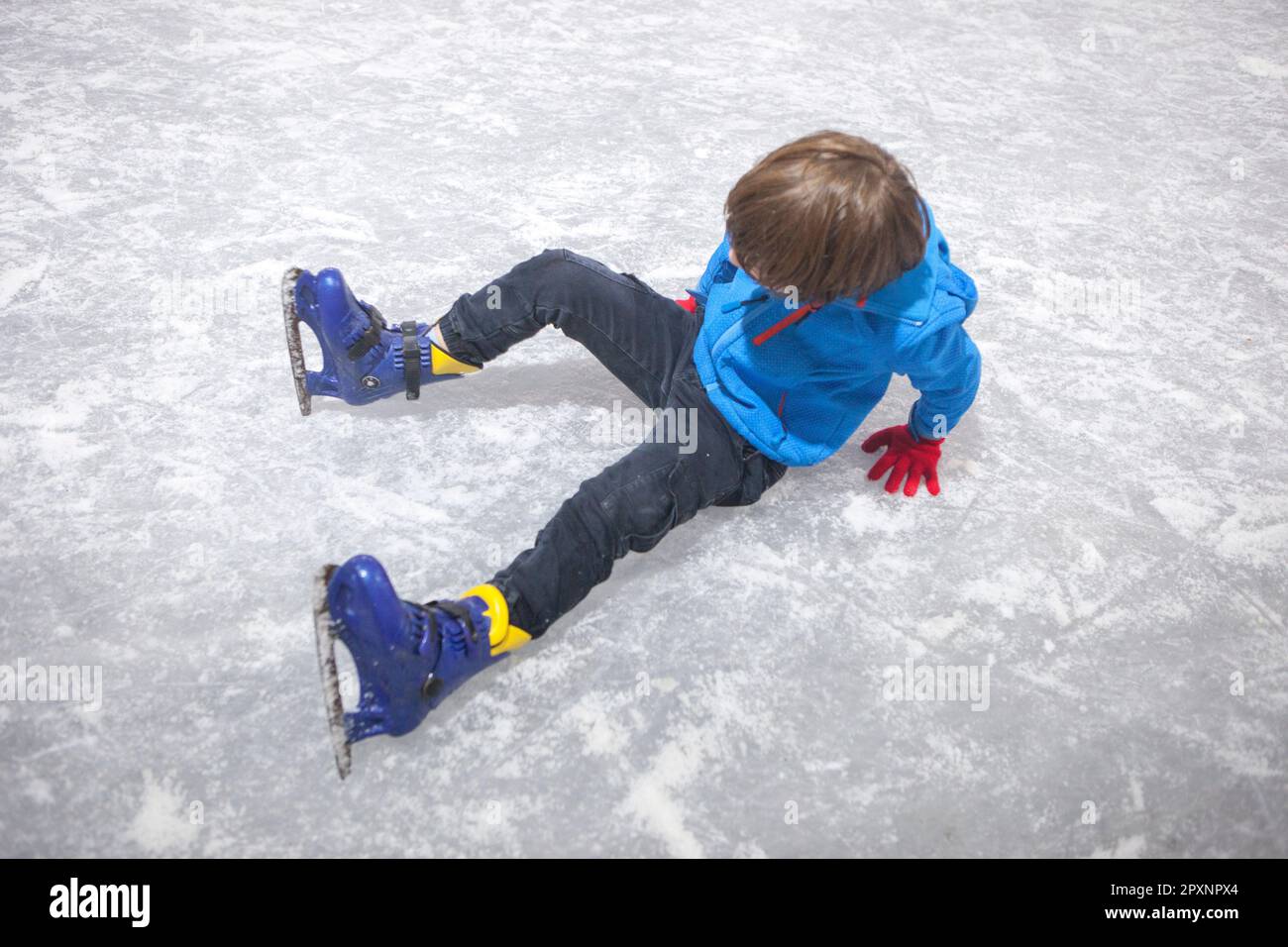 Child boy after suffering a fall on the ice rink. Temporary skating ...