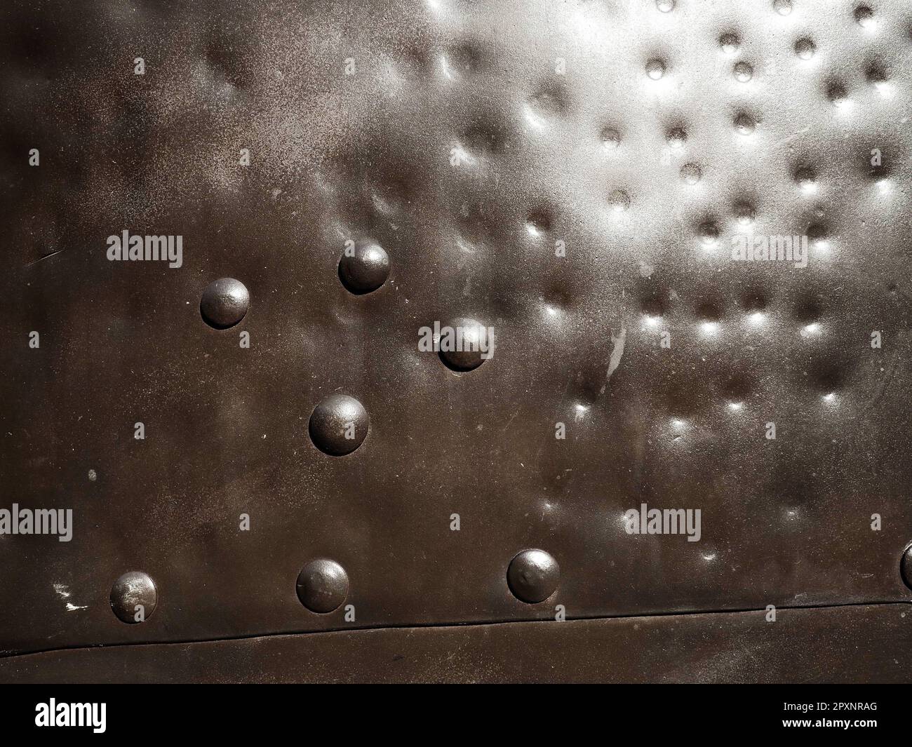 Metal surface with rivets and bolts. Abstract background of a military ...