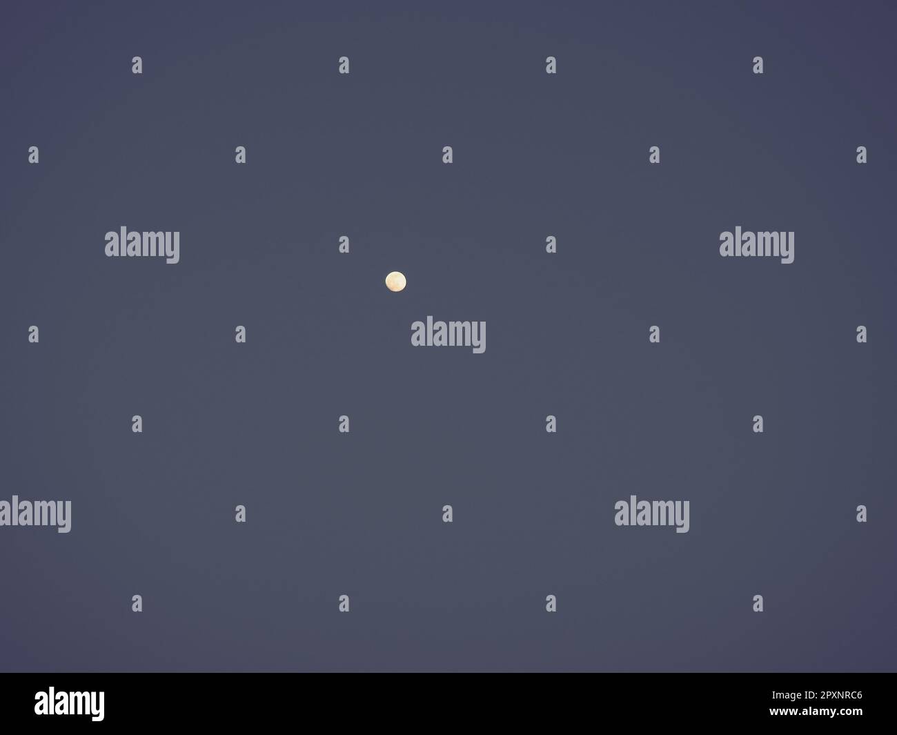 Moon in the night blue sky. White point in the sky. Dark vignetting ...