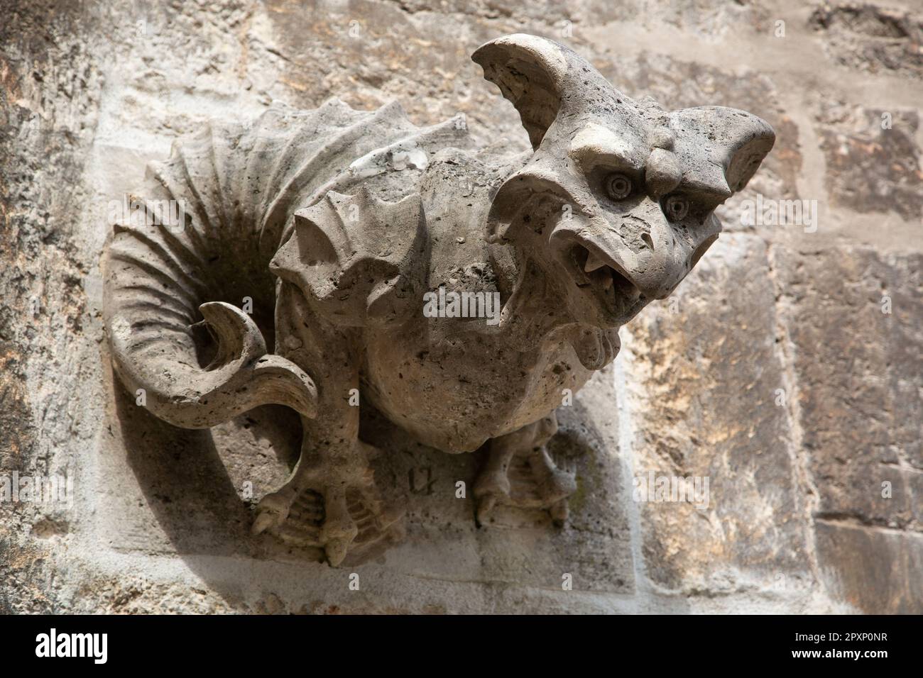 Small stone dragon on the wall of a medieval church Stock Photo - Alamy