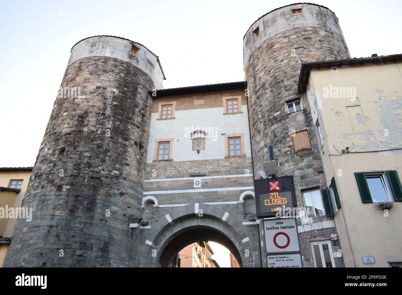 An imposing stone archway built into a wall of an ancient city, with ...