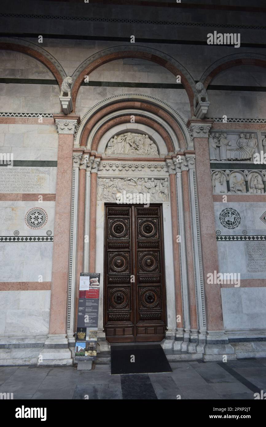 A large, imposing wooden door with a metal handle and hinges, standing ...