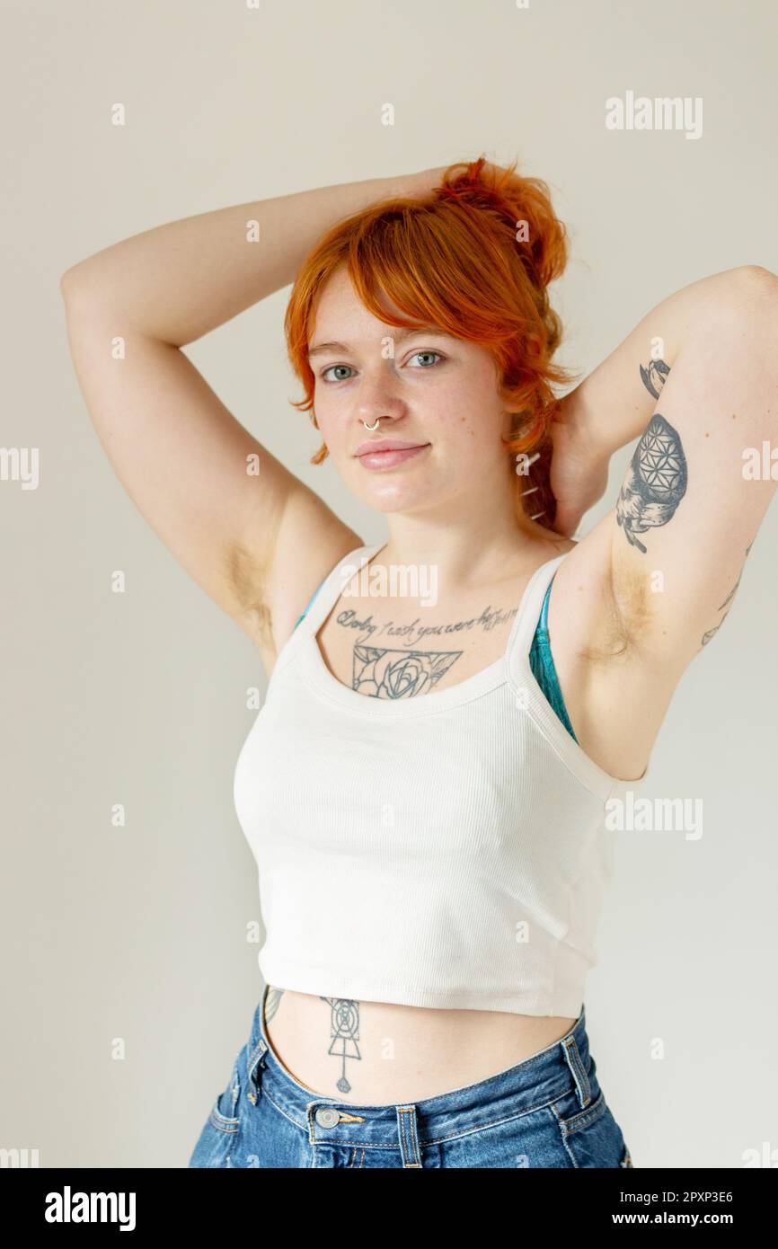 A Beautiful Woman In Her Mid Twenties With Tattoos And Unshaved Armpits With Her Arms Raised