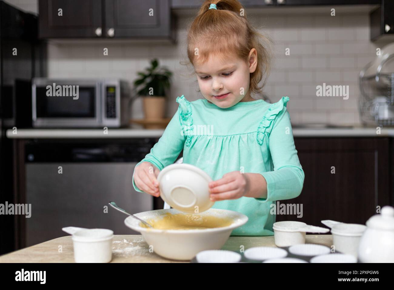 Small happy child cooking. Kid making homemade muffins, mixing ...