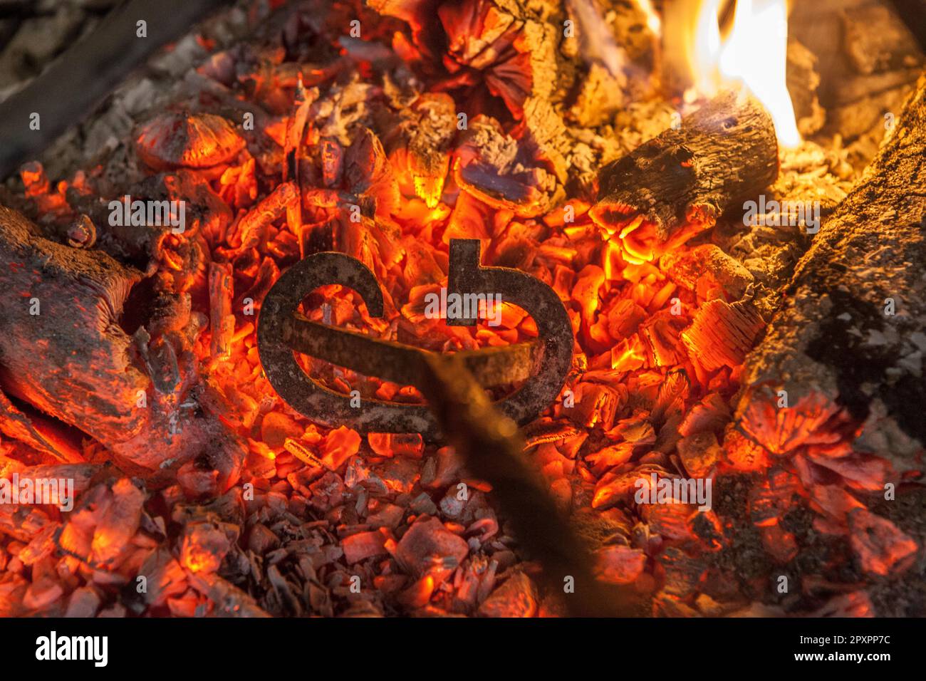 Heating branding iron for cattle over embers. Selective focus Stock ...