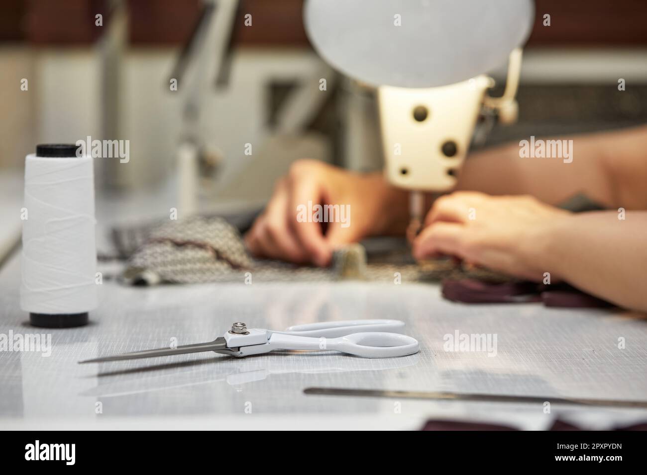 girl seamstress sew on the sewing machine. Women's hands sewing on the sewing machine. Tailoring ...