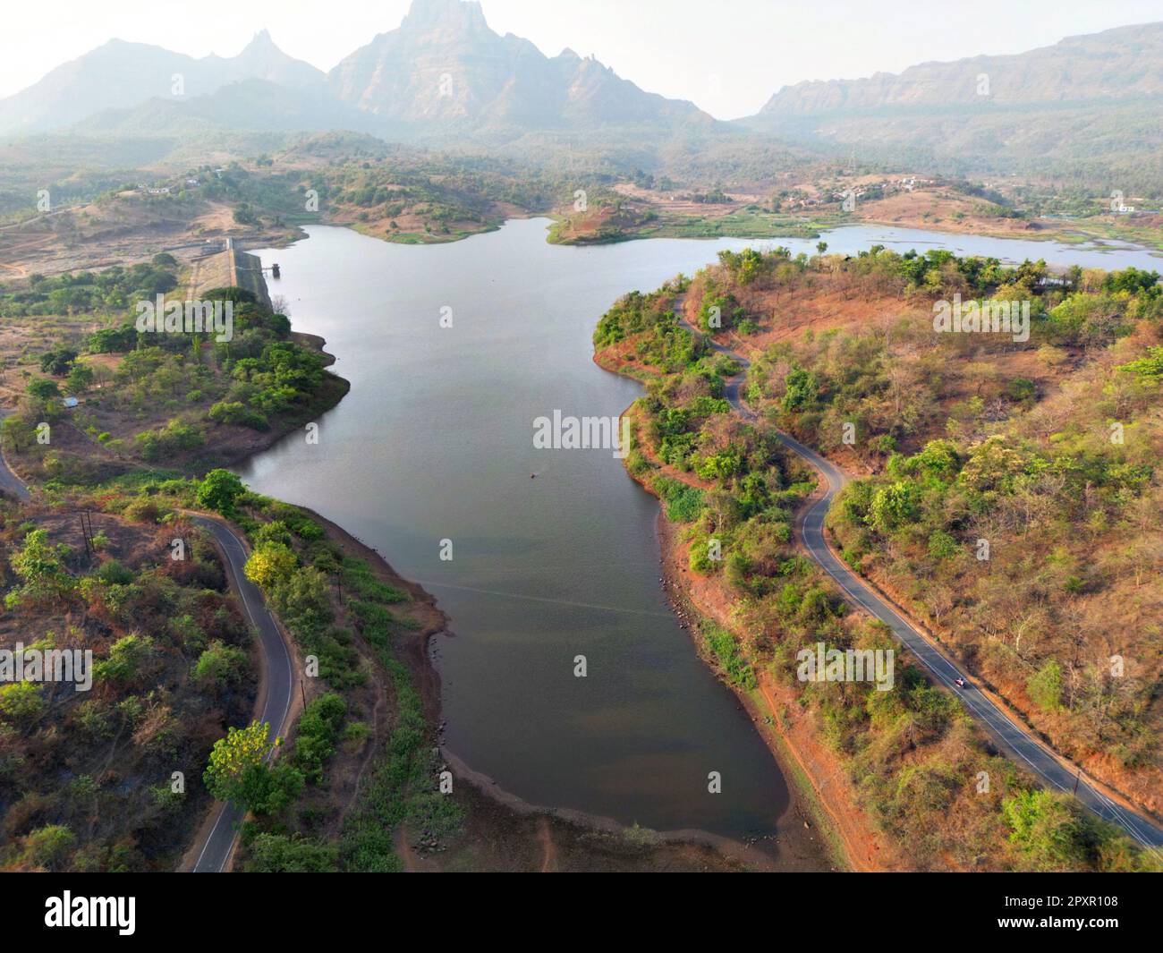 Aerial view of a wide river meandering through rolling hills and lush ...