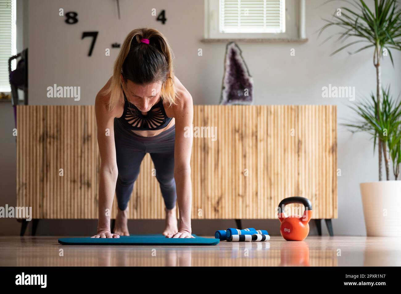 Low angle front view of a fit young woman holding a plank position ...