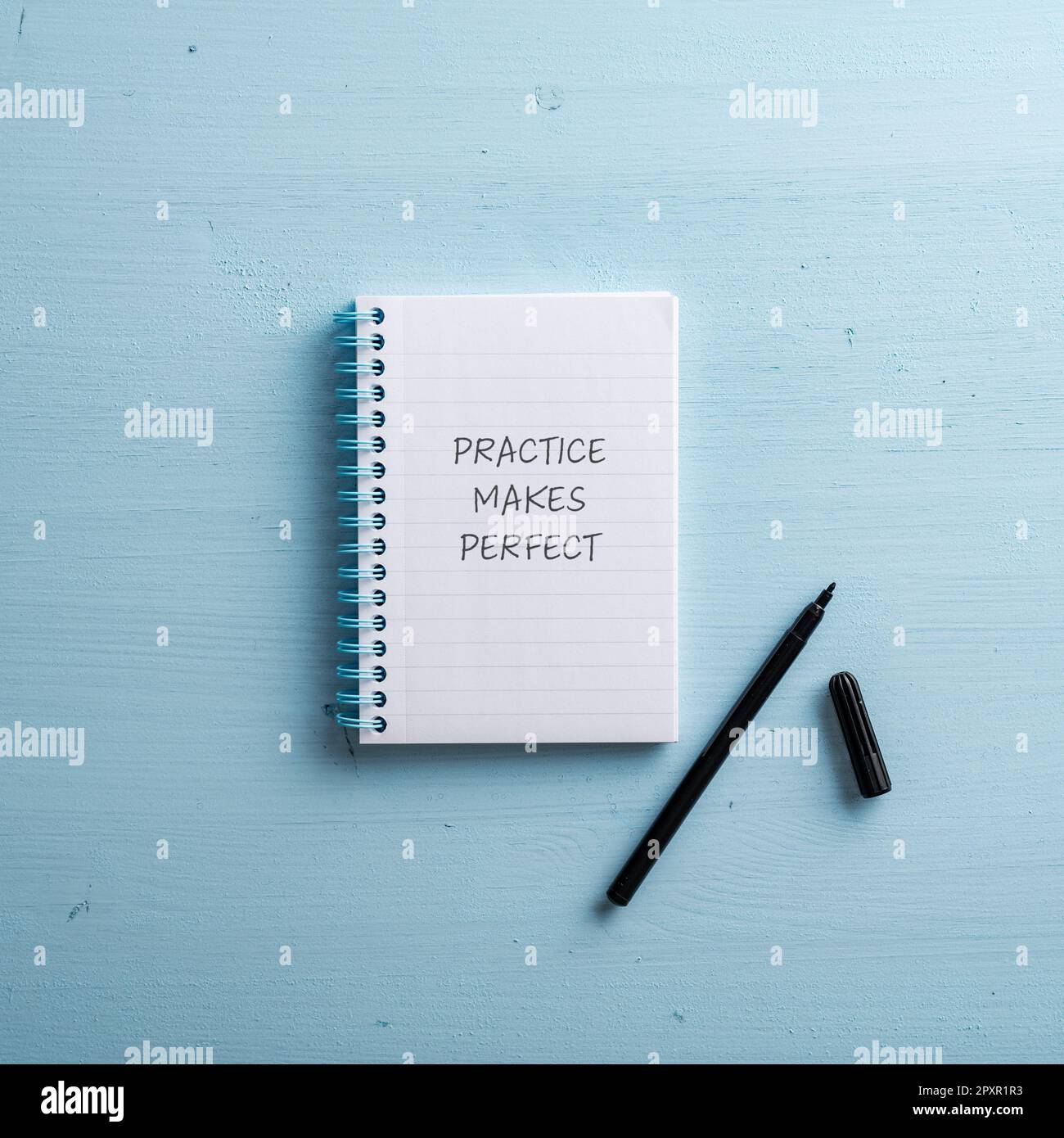 Top view of a spiral notepad with Practice makes perfect sign in it ...