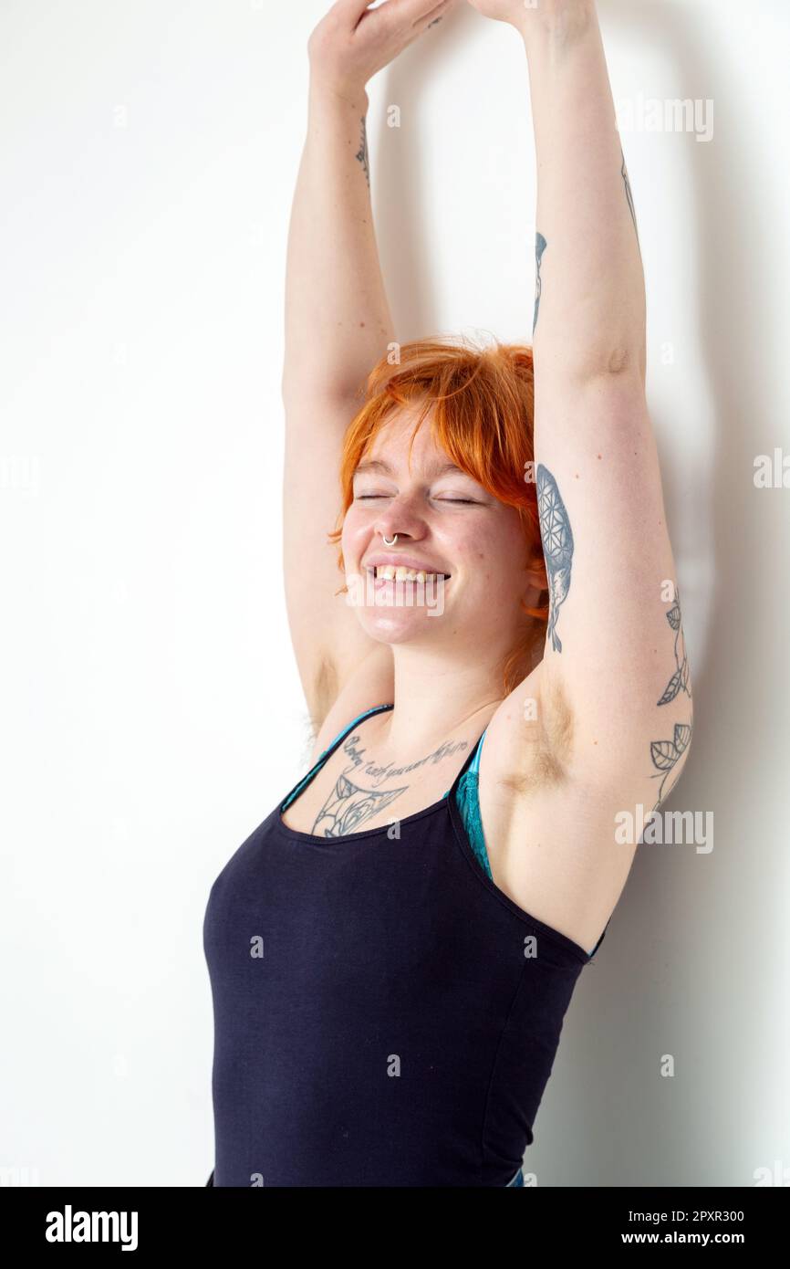 A beautiful woman in her mid twenties with tattoos and unshaved armpits ...