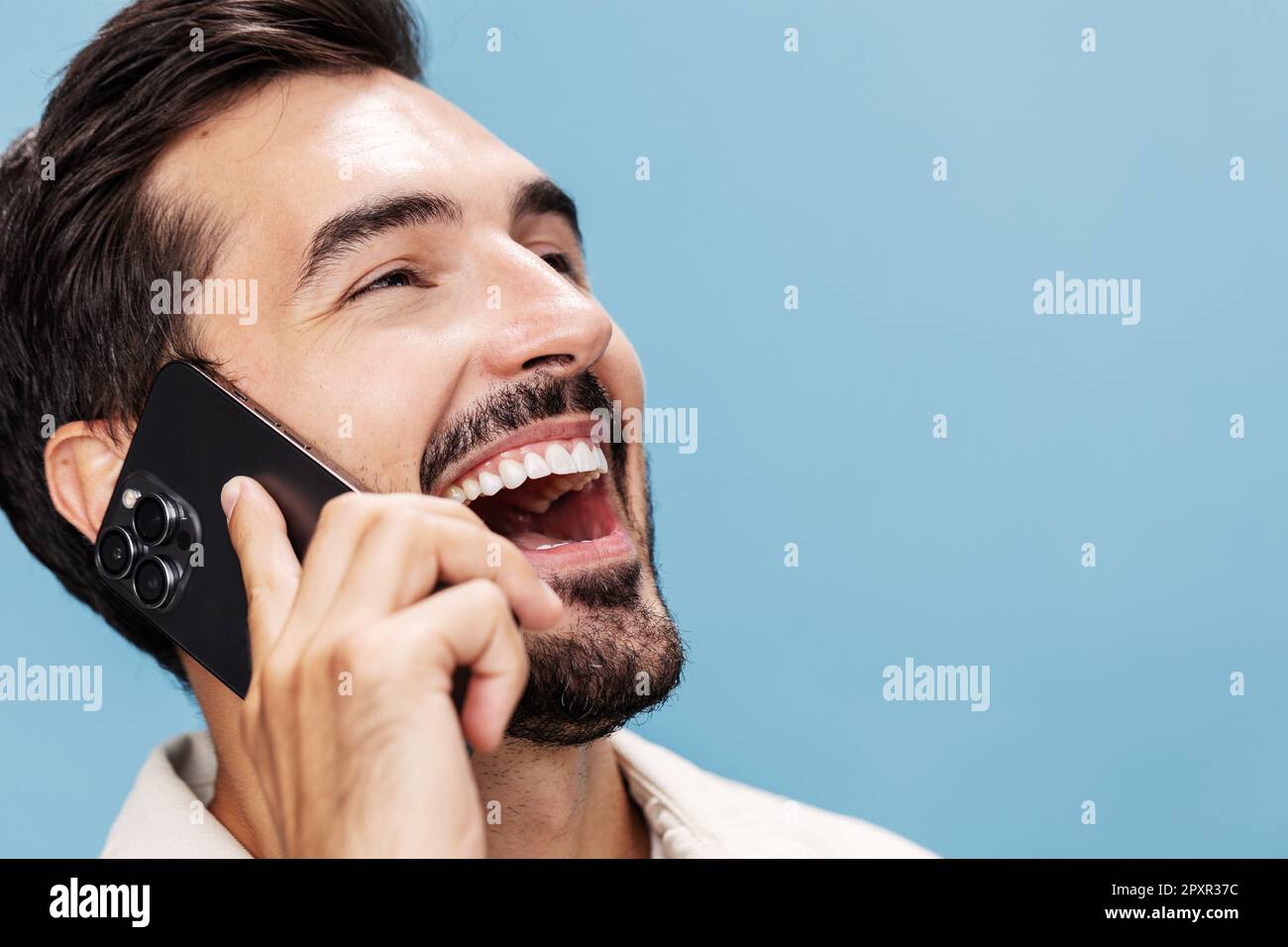 Close-up portrait of a brunette man talking on the phone, smile with ...