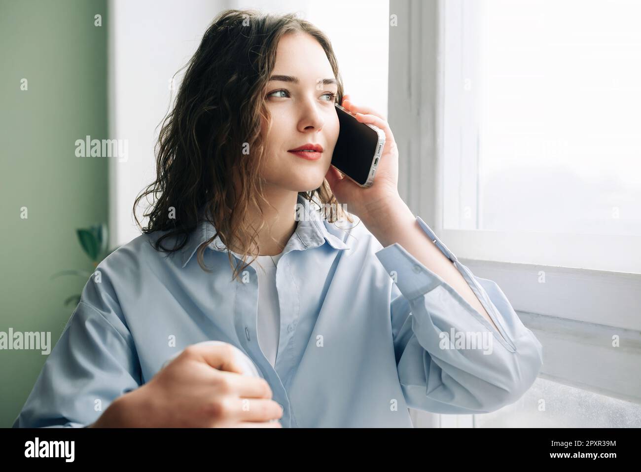 Caring wife by the window eagerly awaiting her husband's arrival. Anxious wife calling her ...